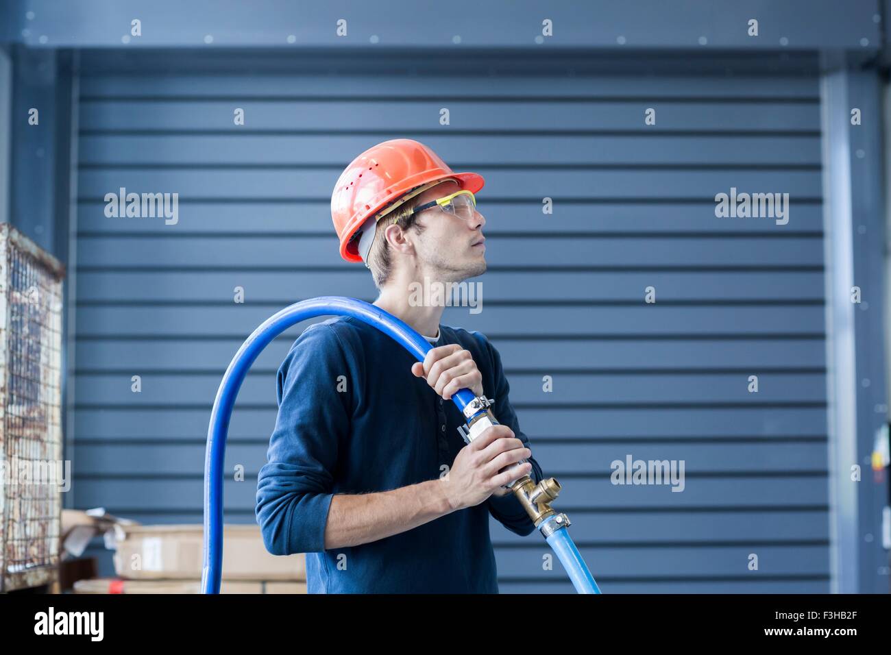 Factory engineer carrying power cable over his shoulder Stock Photo - Alamy