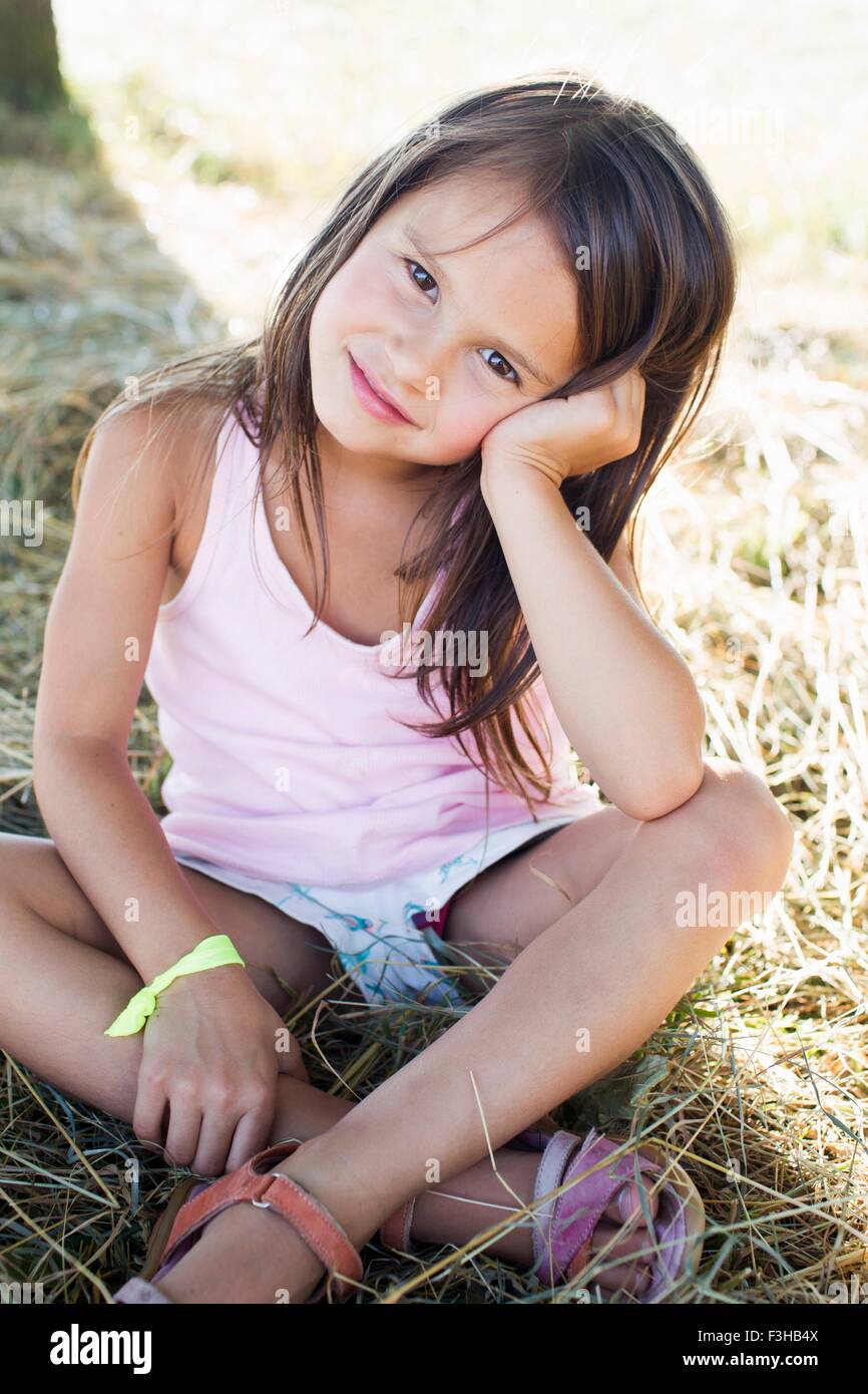 Portrait of girl sitting on grass in park Stock Photo - Alamy