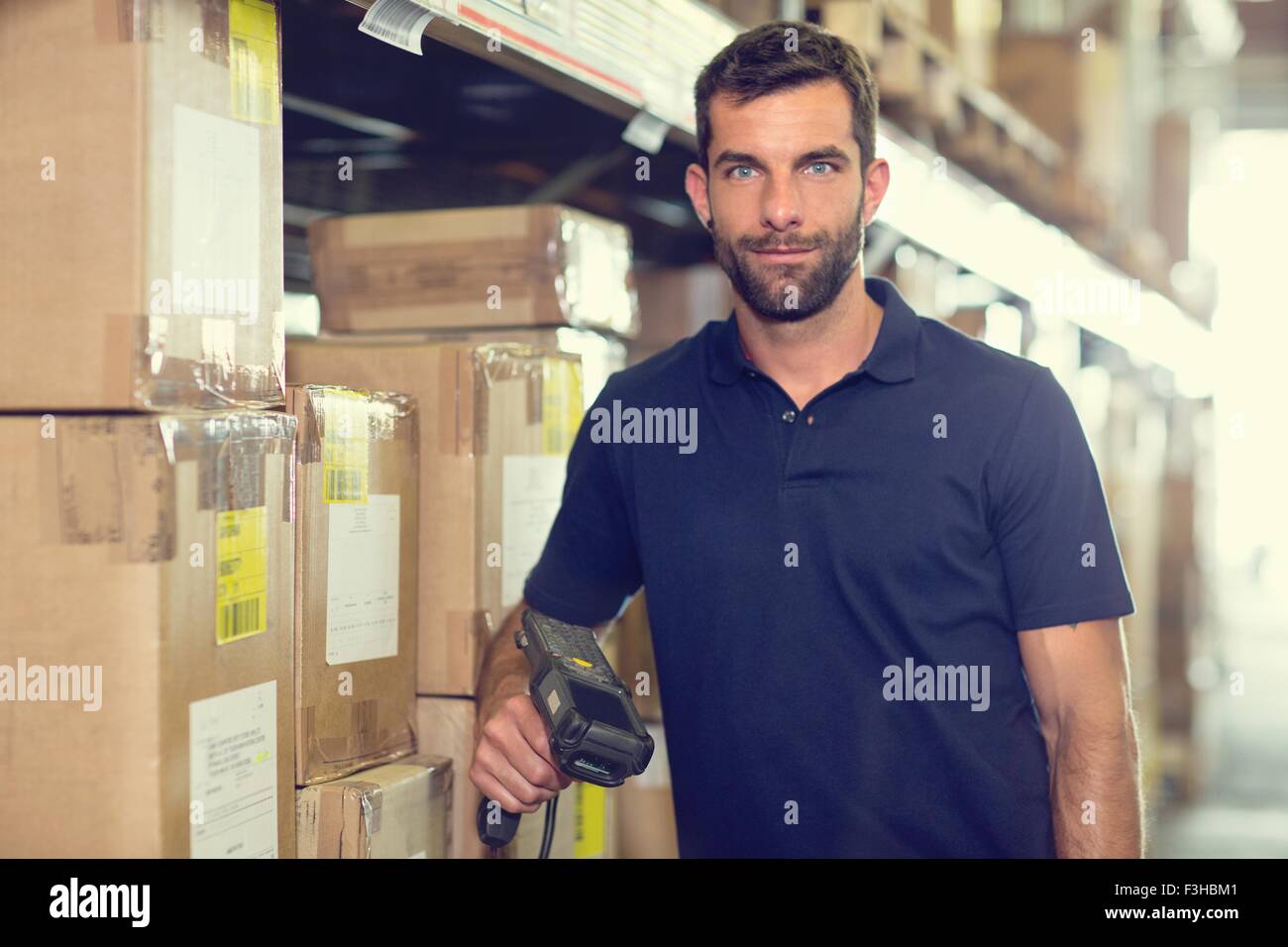 Portrait of warehouse worker using barcode scanner in distribution ...