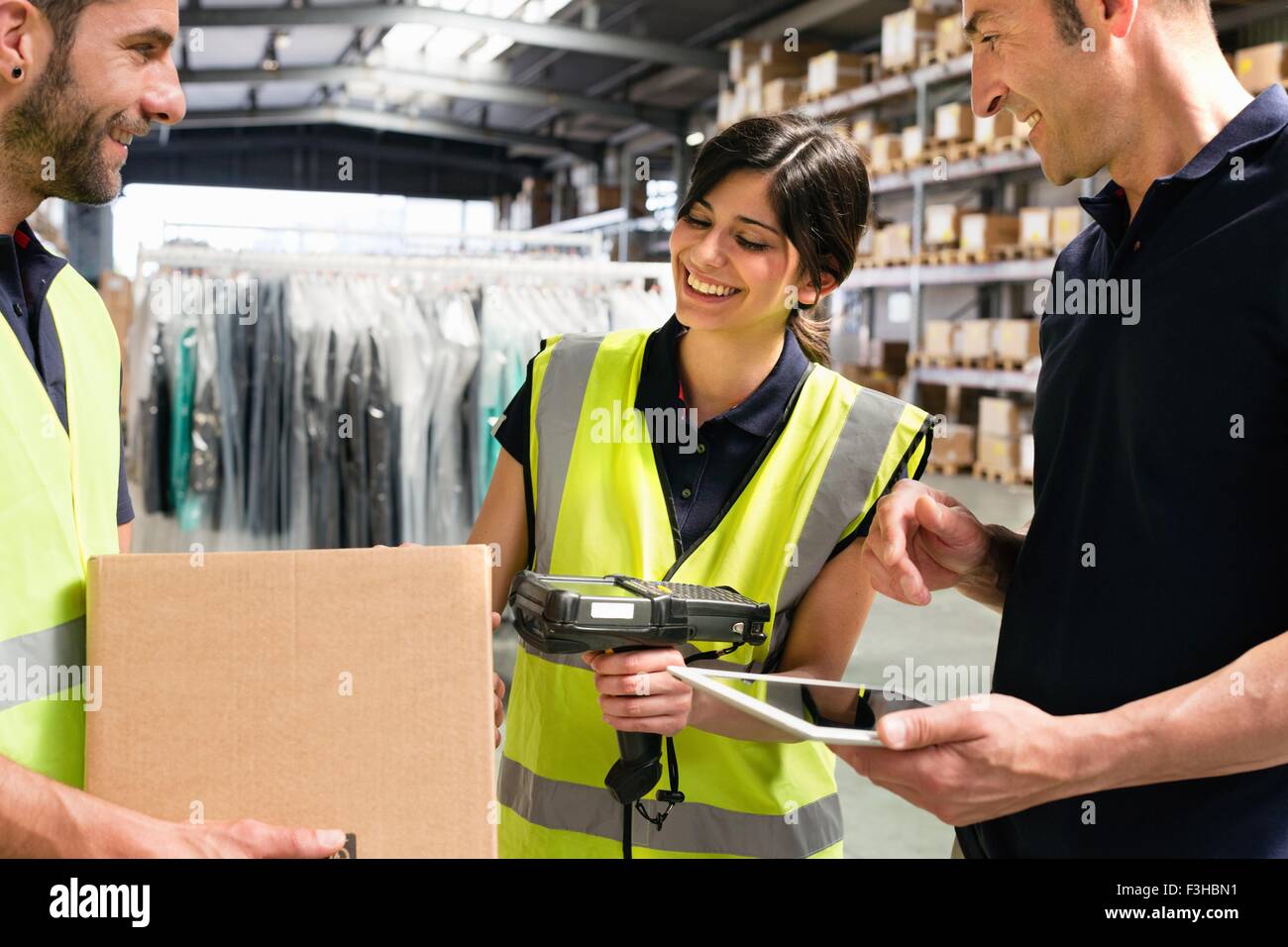 Supervisor instructing workers using digital tablet in distribution ...