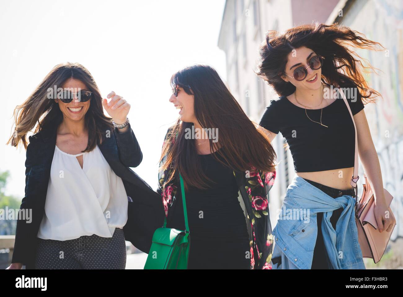 Three young female friends strolling and fooling around Stock Photo - Alamy