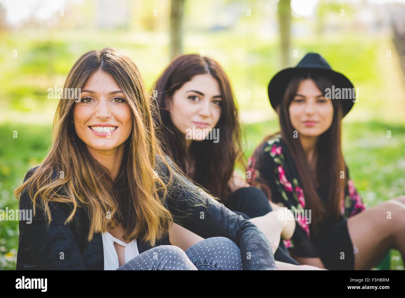 Three friends sitting park hi-res stock photography and images - Alamy