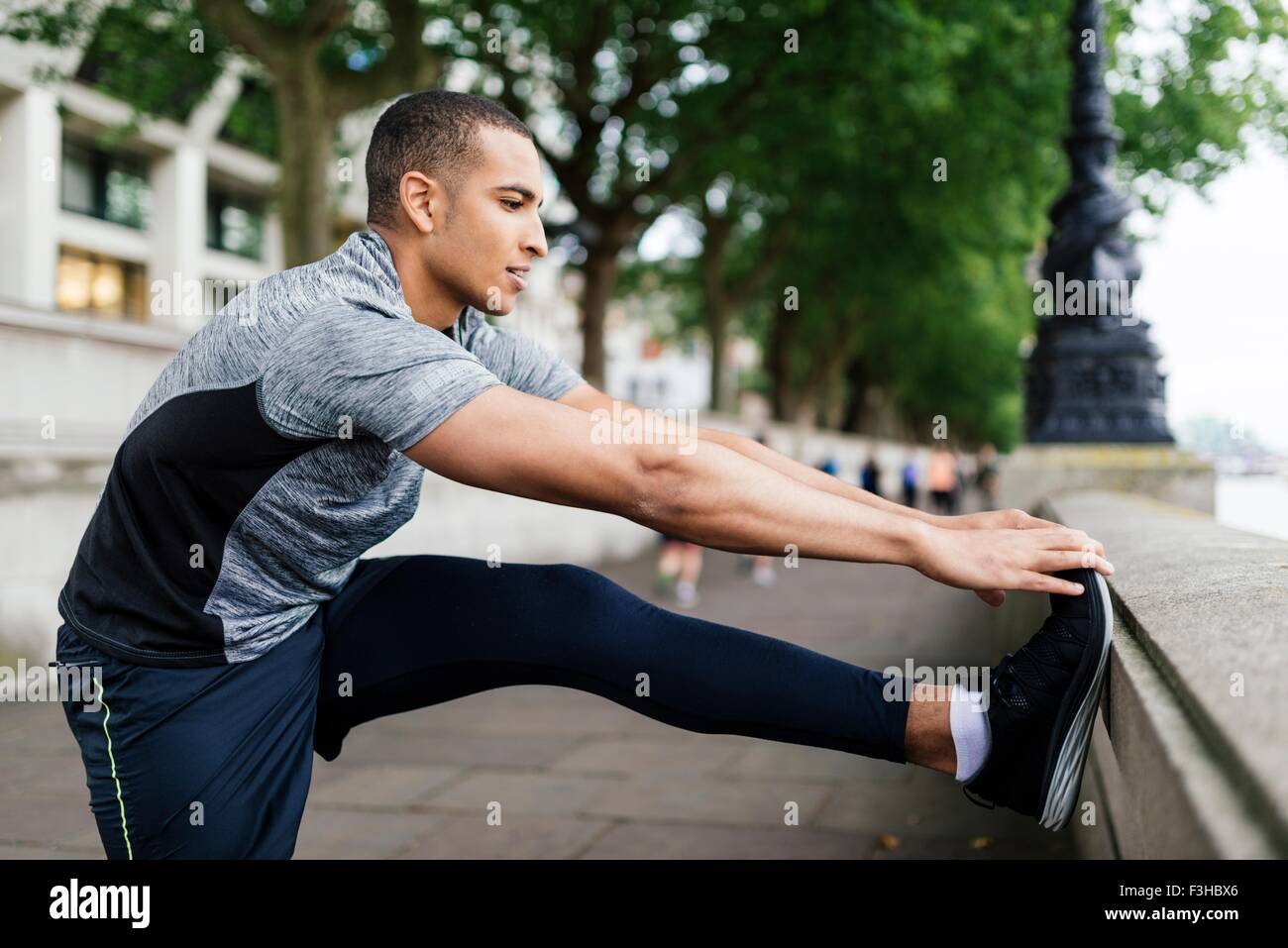 Male runner doing warm up preparation on riverside Stock Photo - Alamy