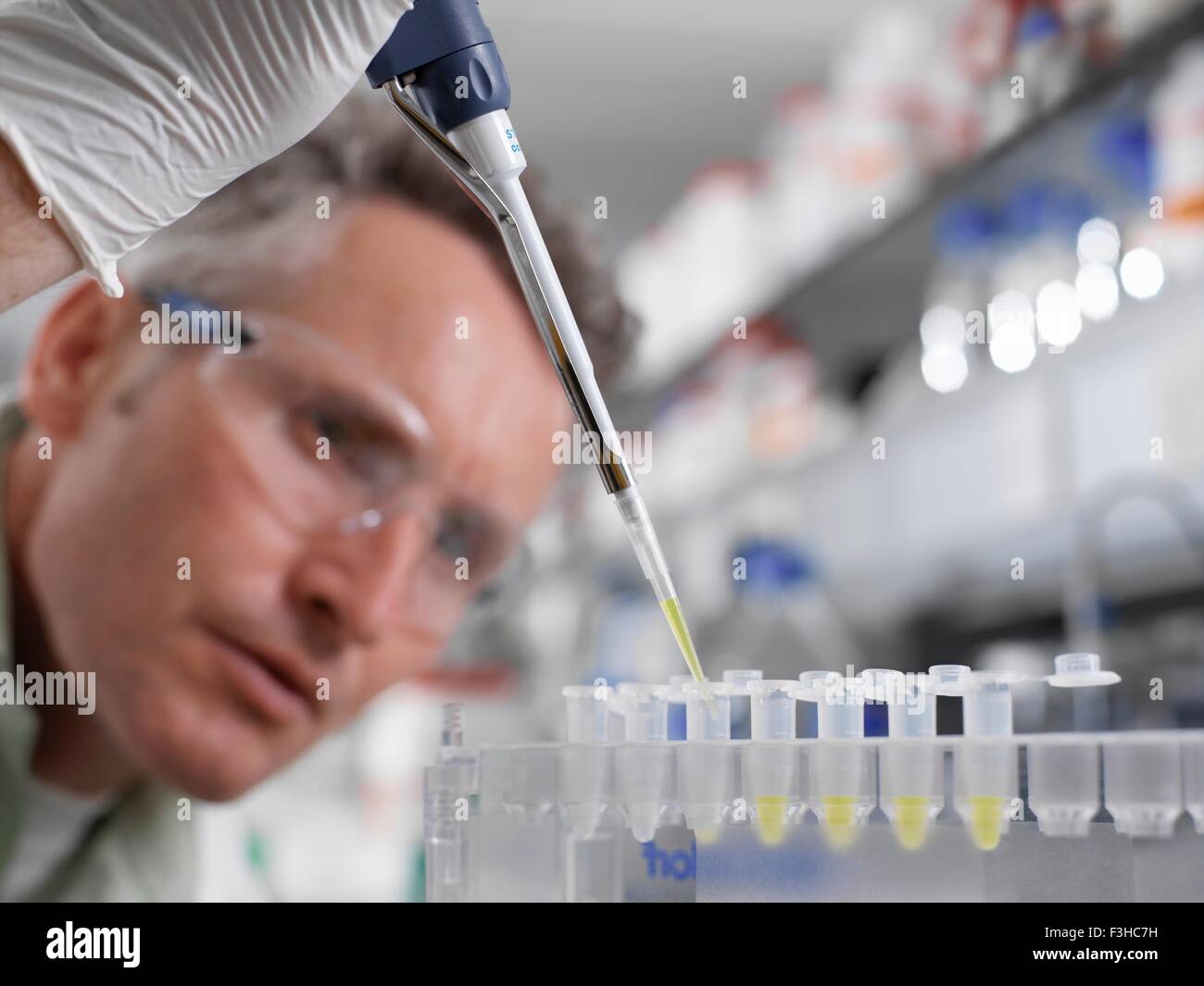 Scientist pipetting sample into eppendorf tube in laboratory Stock ...