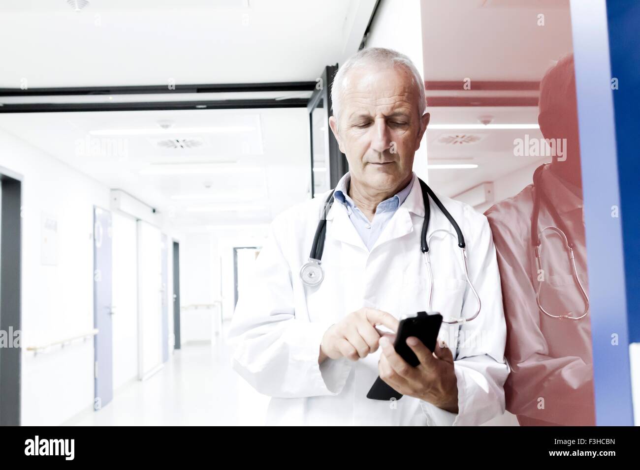 Male doctor using smartphone Stock Photo - Alamy