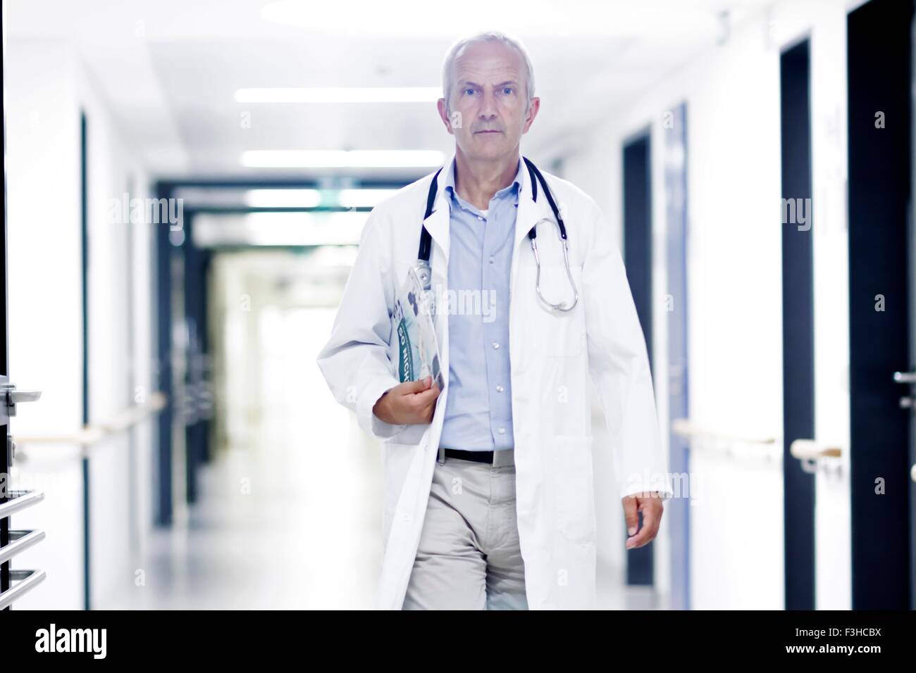 Male doctor walking along corridor Stock Photo - Alamy