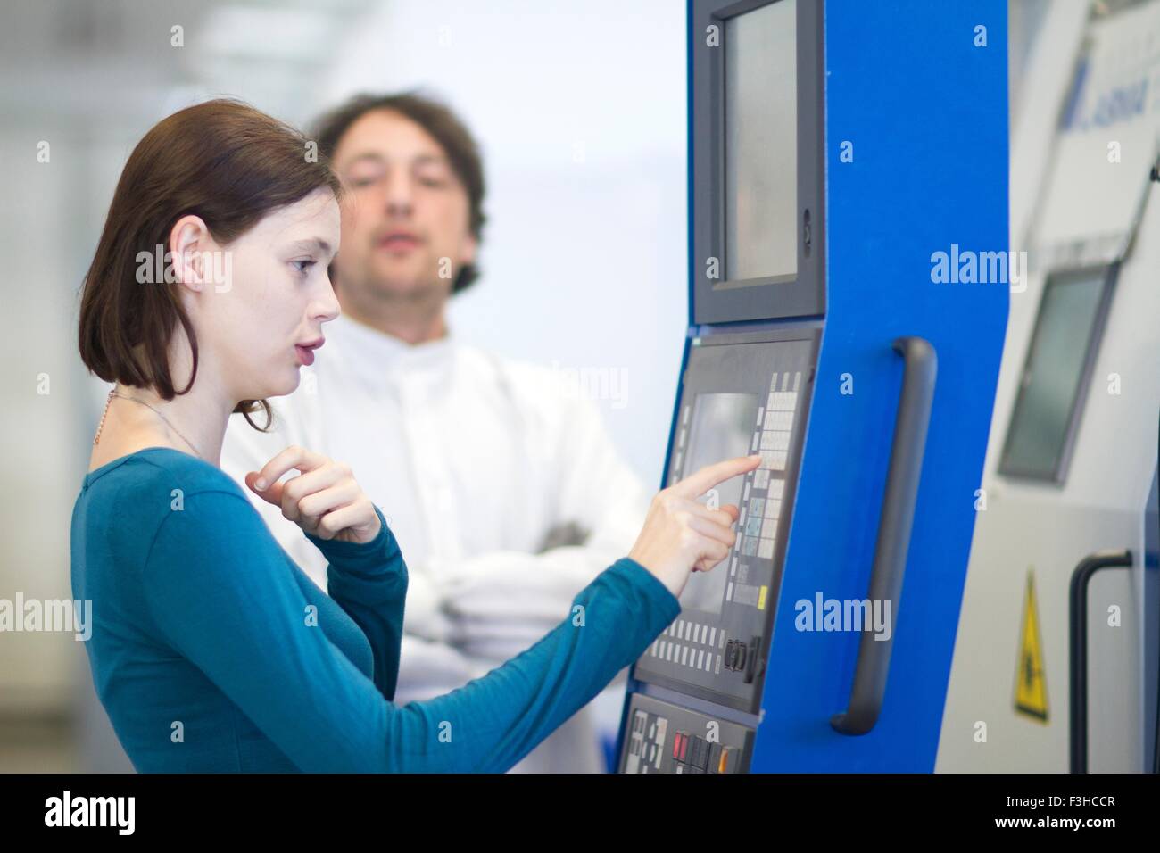 Side view of young woman pressing keypad on scientific equipment Stock ... Side view of young woman pressing keypad on scientific equipment Stock ...