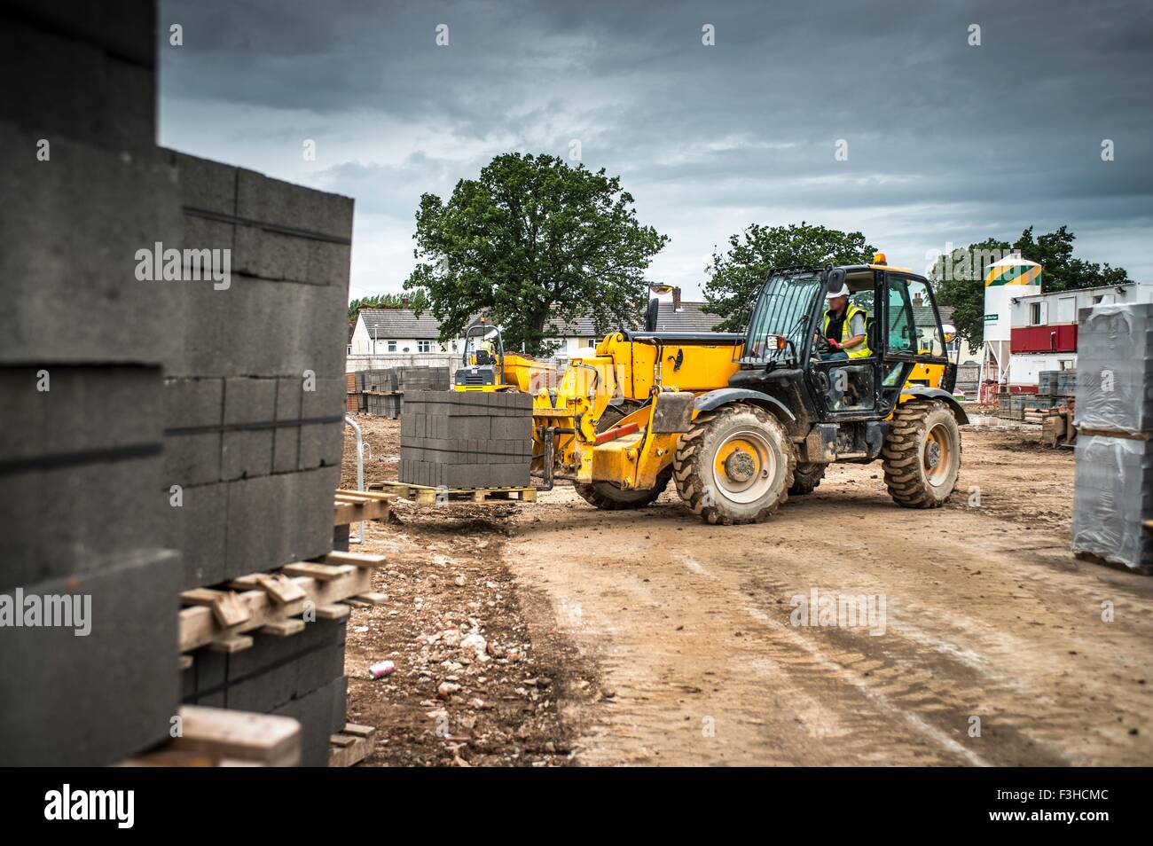 Tractor, building materials on construction site Stock Photo - Alamy