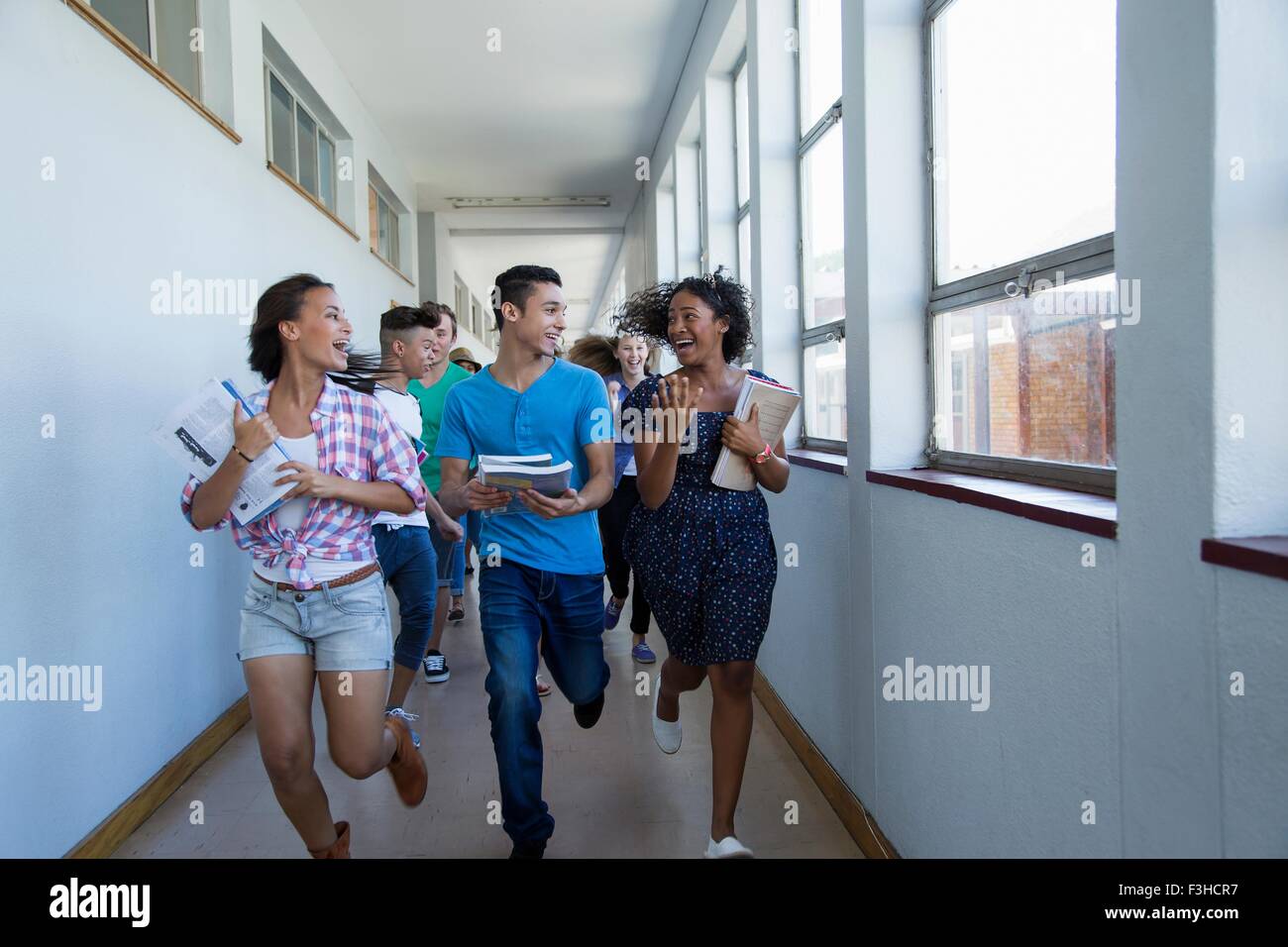 Students running down hallway, laughing Stock Photo - Alamy