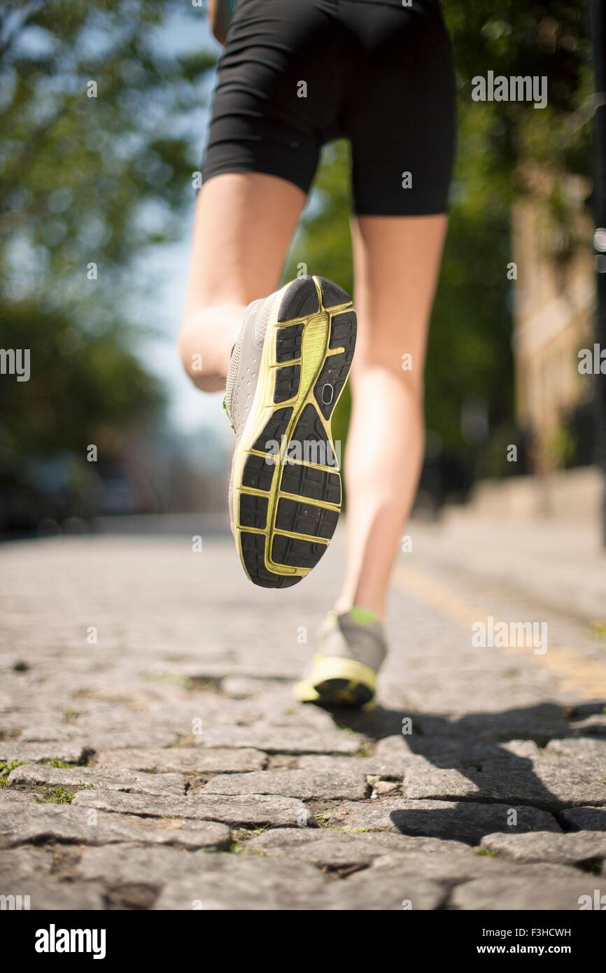 Runner jogging on cobbled street Stock Photo - Alamy
