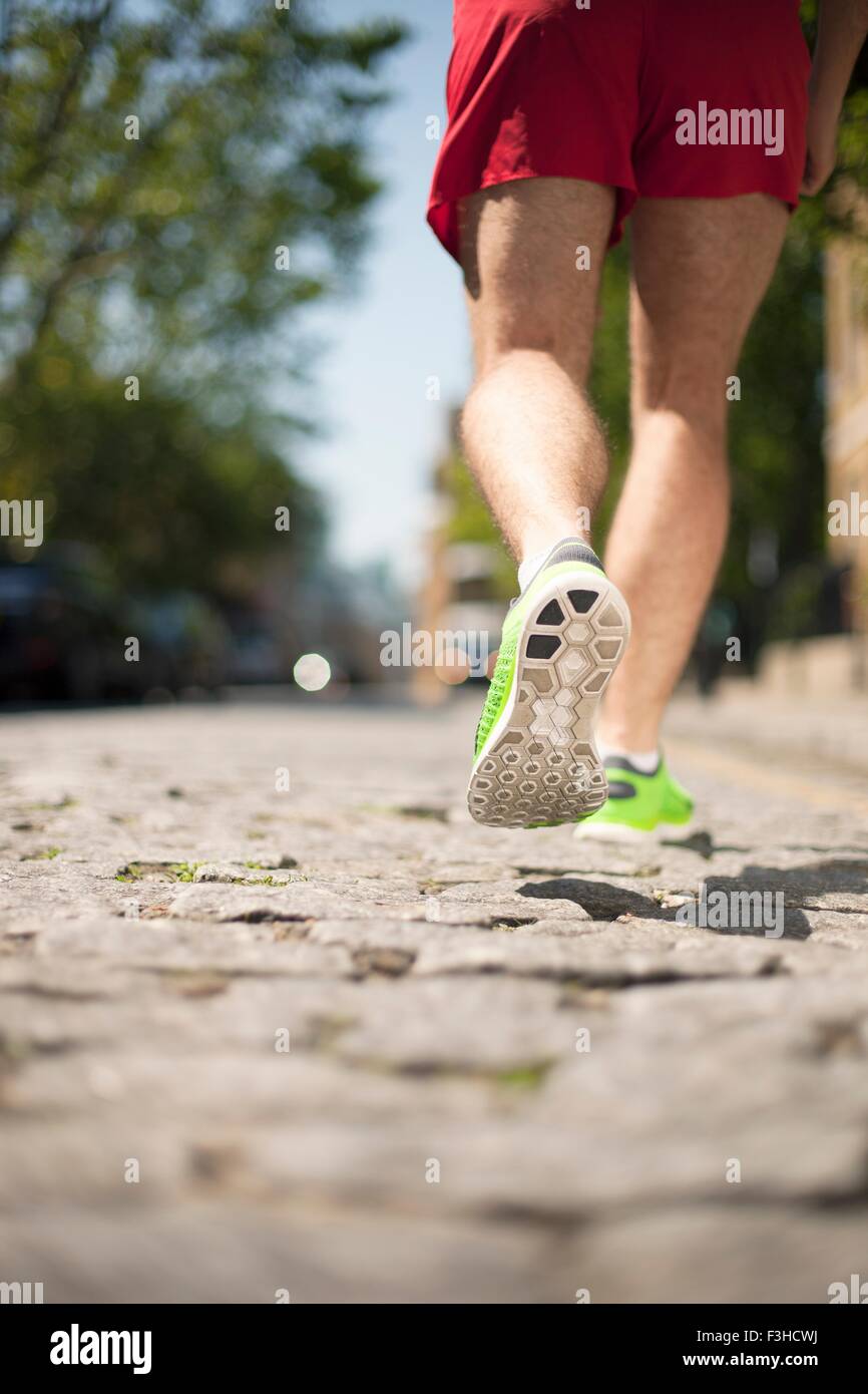 Runner jogging on cobbled street Stock Photo - Alamy