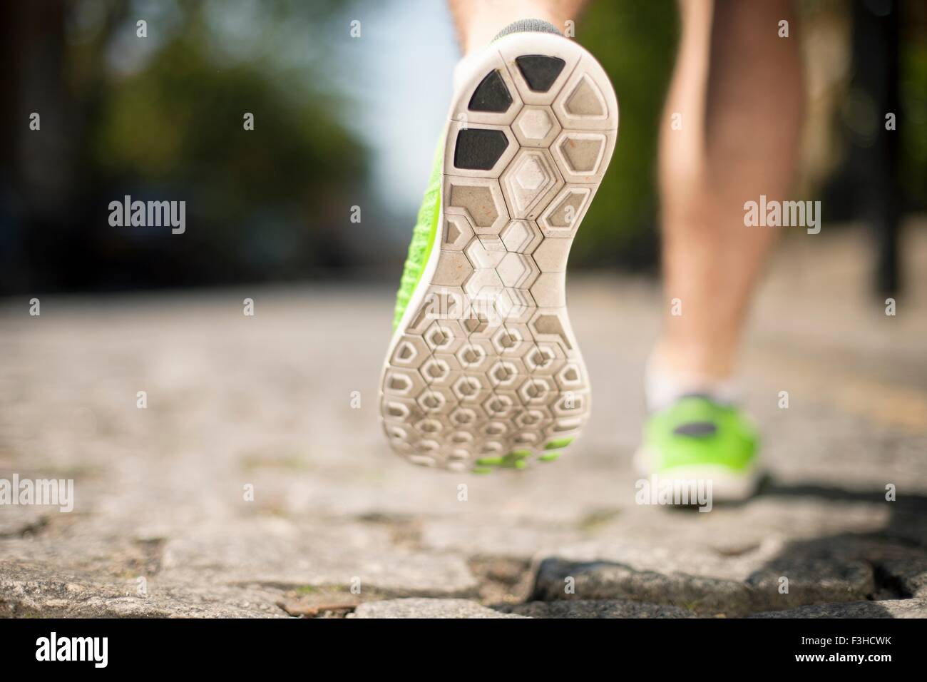 Runner jogging on cobbled street Stock Photo - Alamy