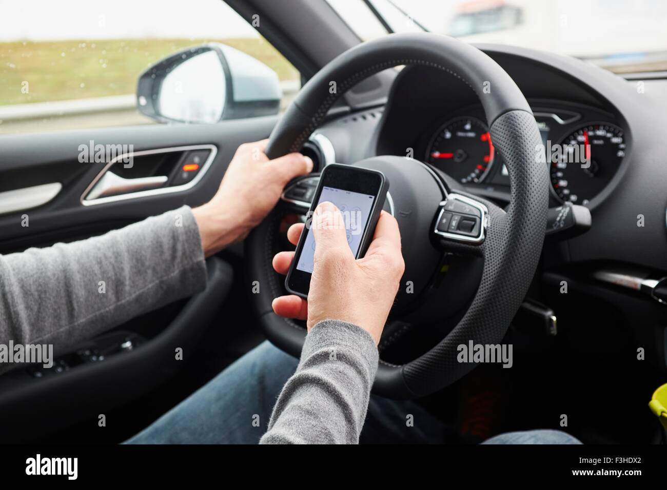 Cropped shot of man using smartphone whilst driving Stock Photo - Alamy