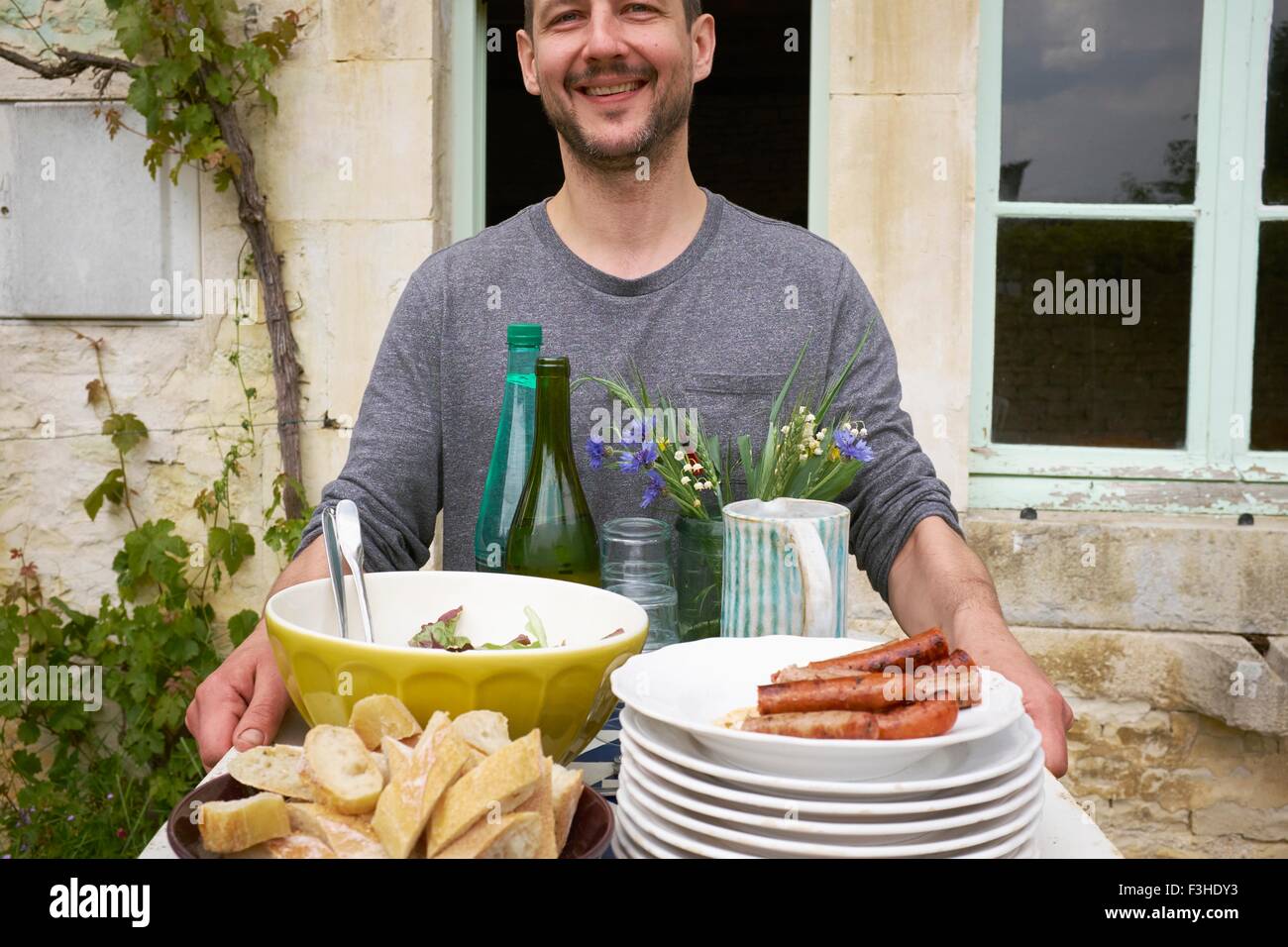 Man carrying tray of food outside house Stock Photo - Alamy
