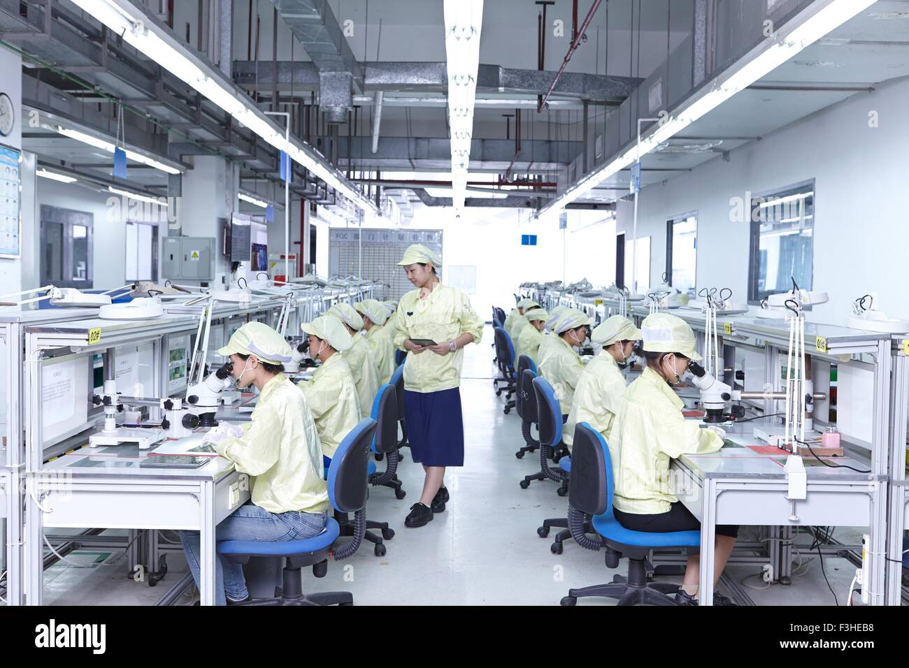 Supervisor overseeing quality check station factory producing flexible electronic circuit boards ...
