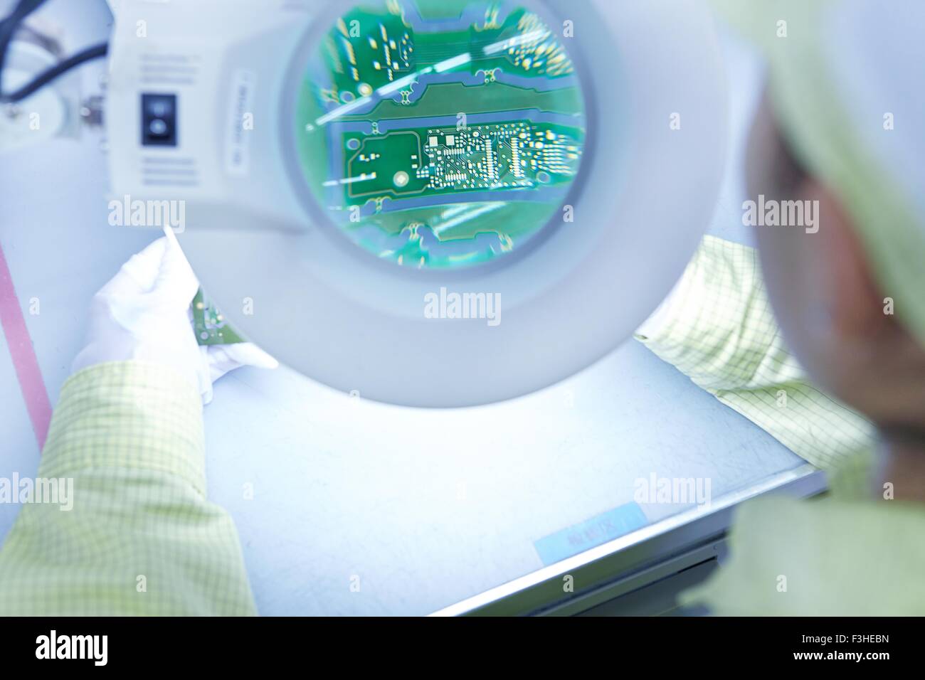 Young woman magnifier quality check station factory producing flexible ...