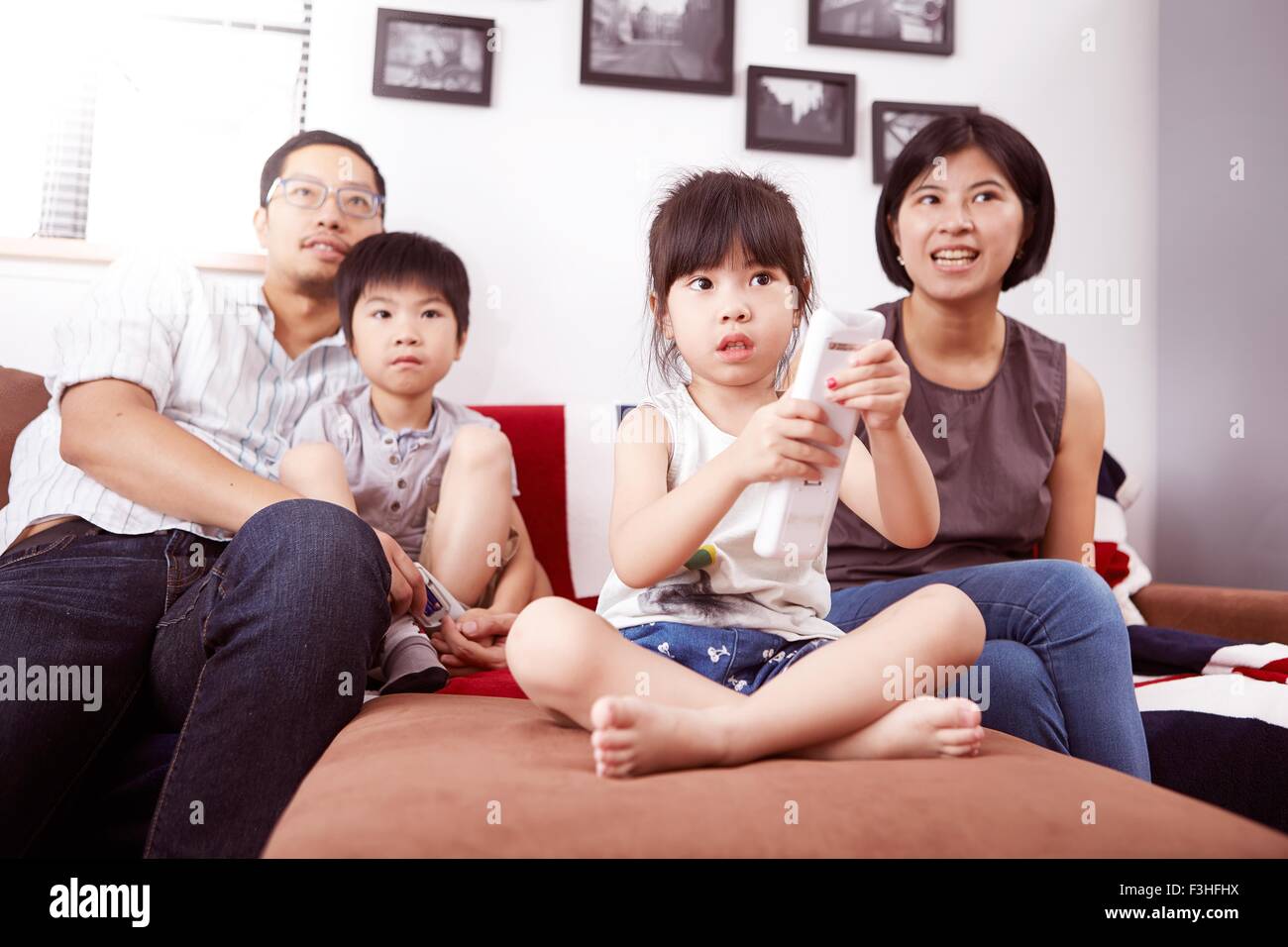Young, modern Chinese family of parents and two young children sitting ...
