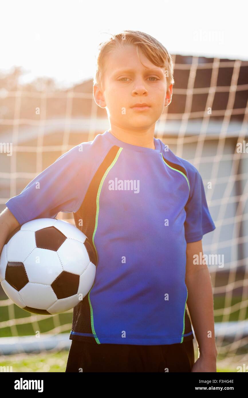 Portrait of boy football player holding football in front of goal Stock ...