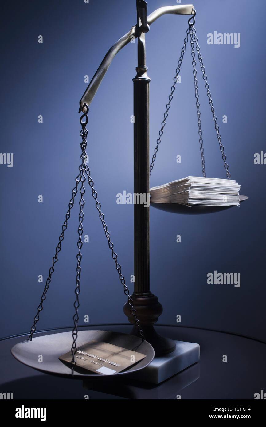 Credit card and stack of money on weighing scales Stock Photo - Alamy