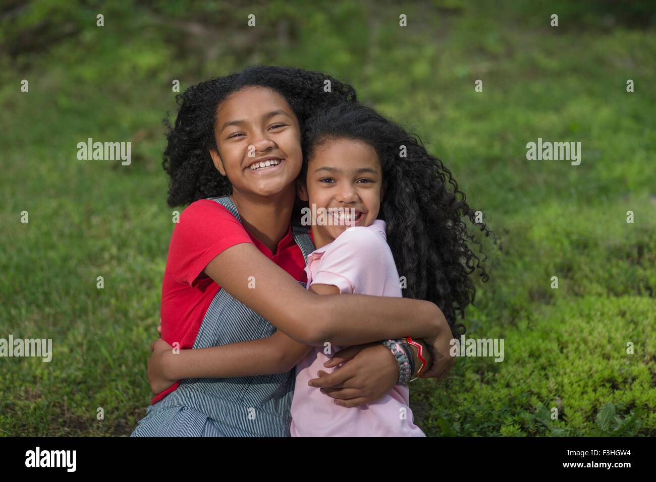 Portrait of girls hugging looking at camera smiling Stock Photo - Alamy
