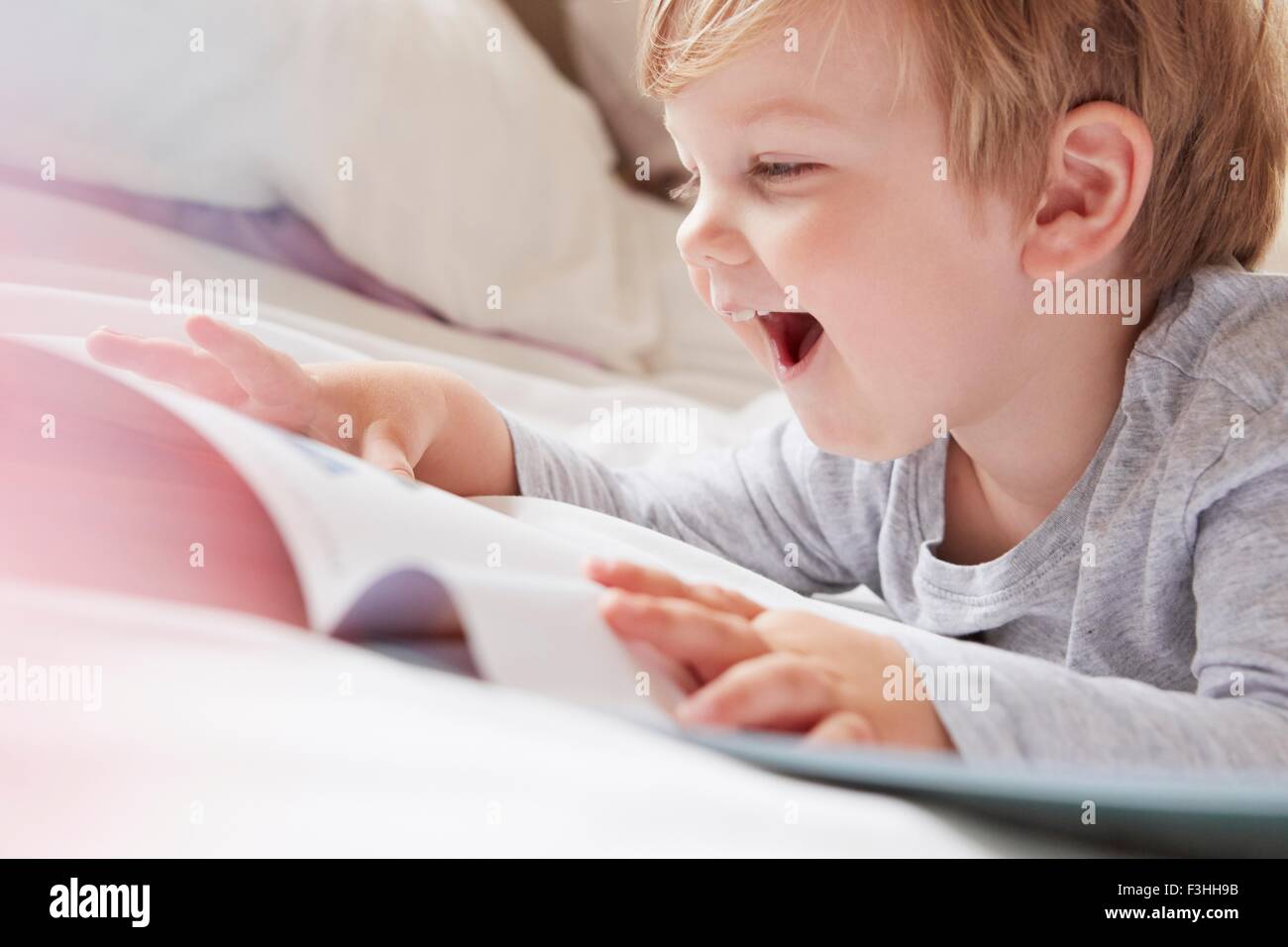 Boy laughing reading book hi-res stock photography and images - Alamy