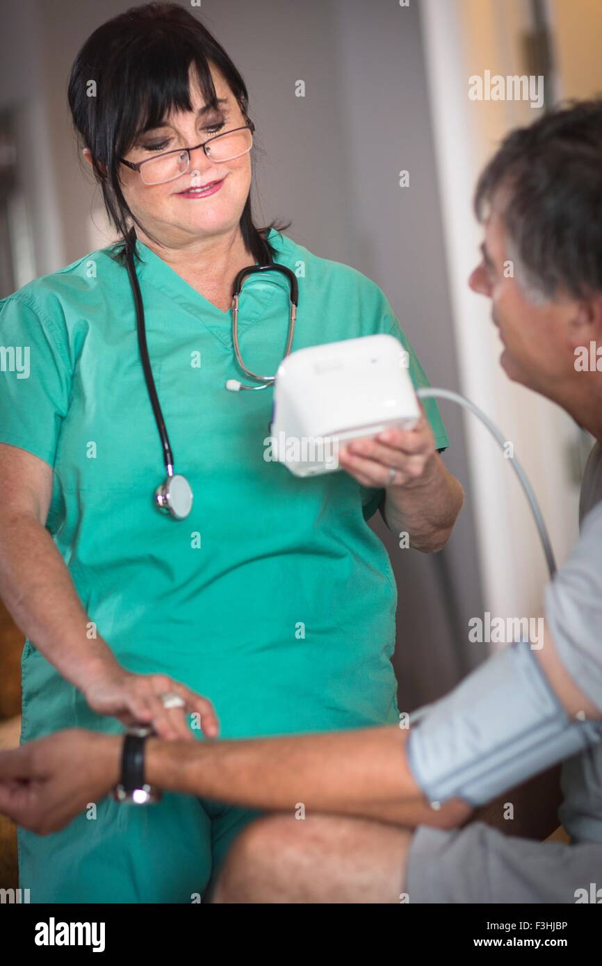 Senior female nurse checking patient's pulse Stock Photo - Alamy
