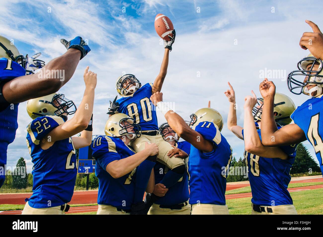 Teenage and young male American football team celebrating together on ...