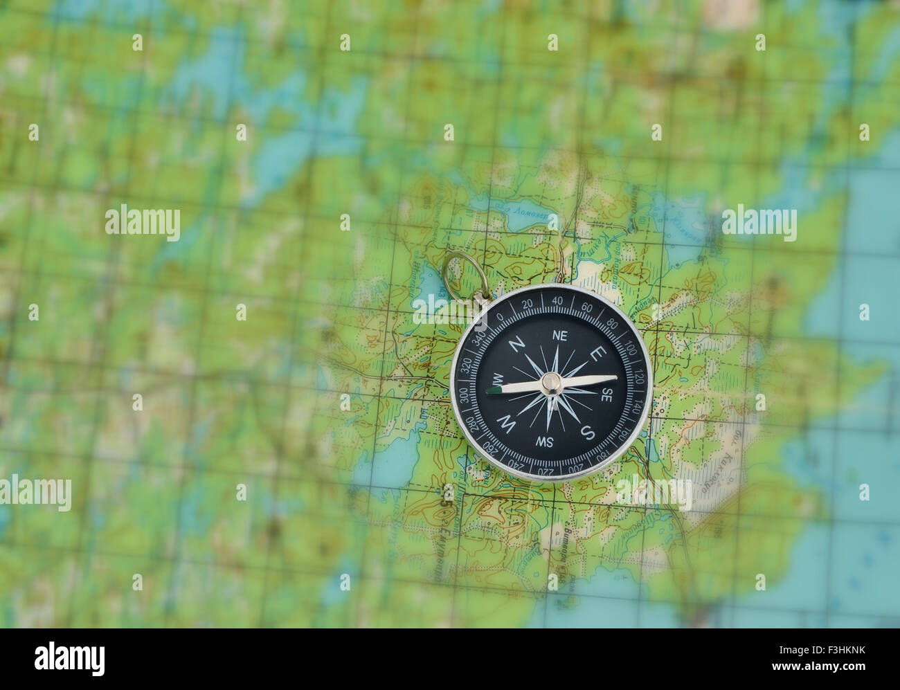 Magnetic compass is located on a topographic map. Orienteering in the ...