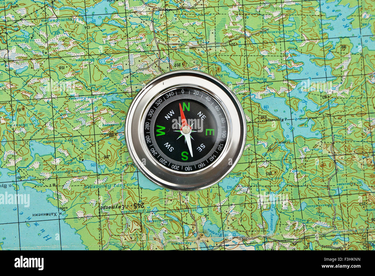 Magnetic compass is located on a topographic map. Orienteering in the ...