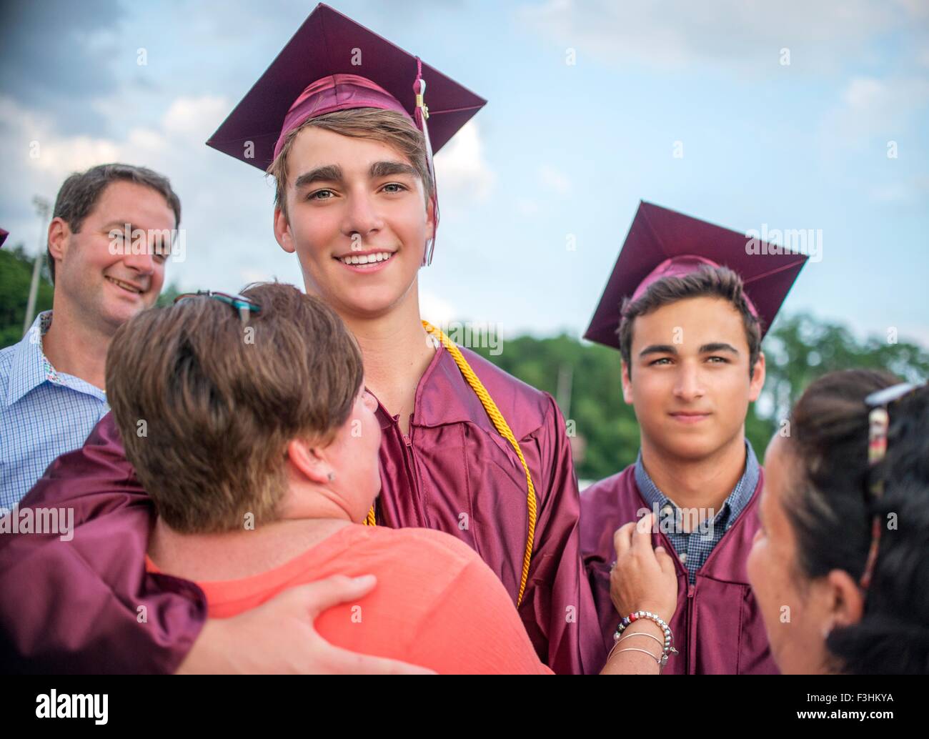 Two young men hugging family at graduation ceremony Stock Photo - Alamy