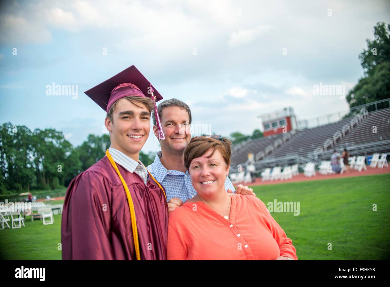 Young man standing with mother and father at graduation ceremony Stock ...