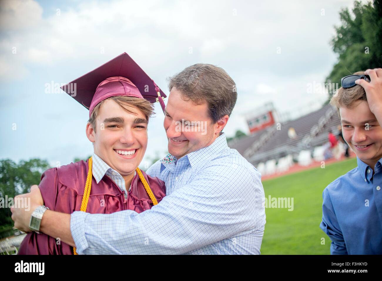 Young man being hugged by father at graduation ceremony Stock Photo - Alamy