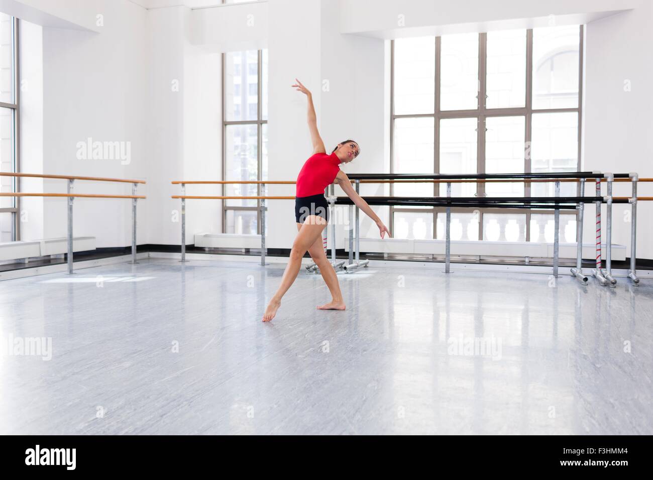 Young woman in dance studio dancing, head back, arms raised Stock Photo ...