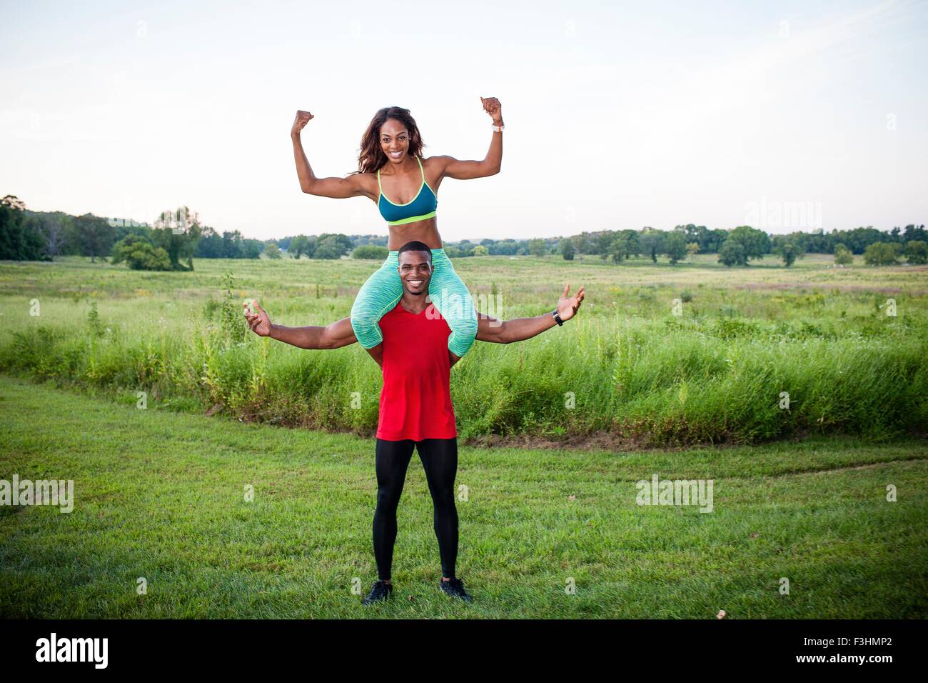 Portrait of young man training with girlfriend on his shoulders Stock ...