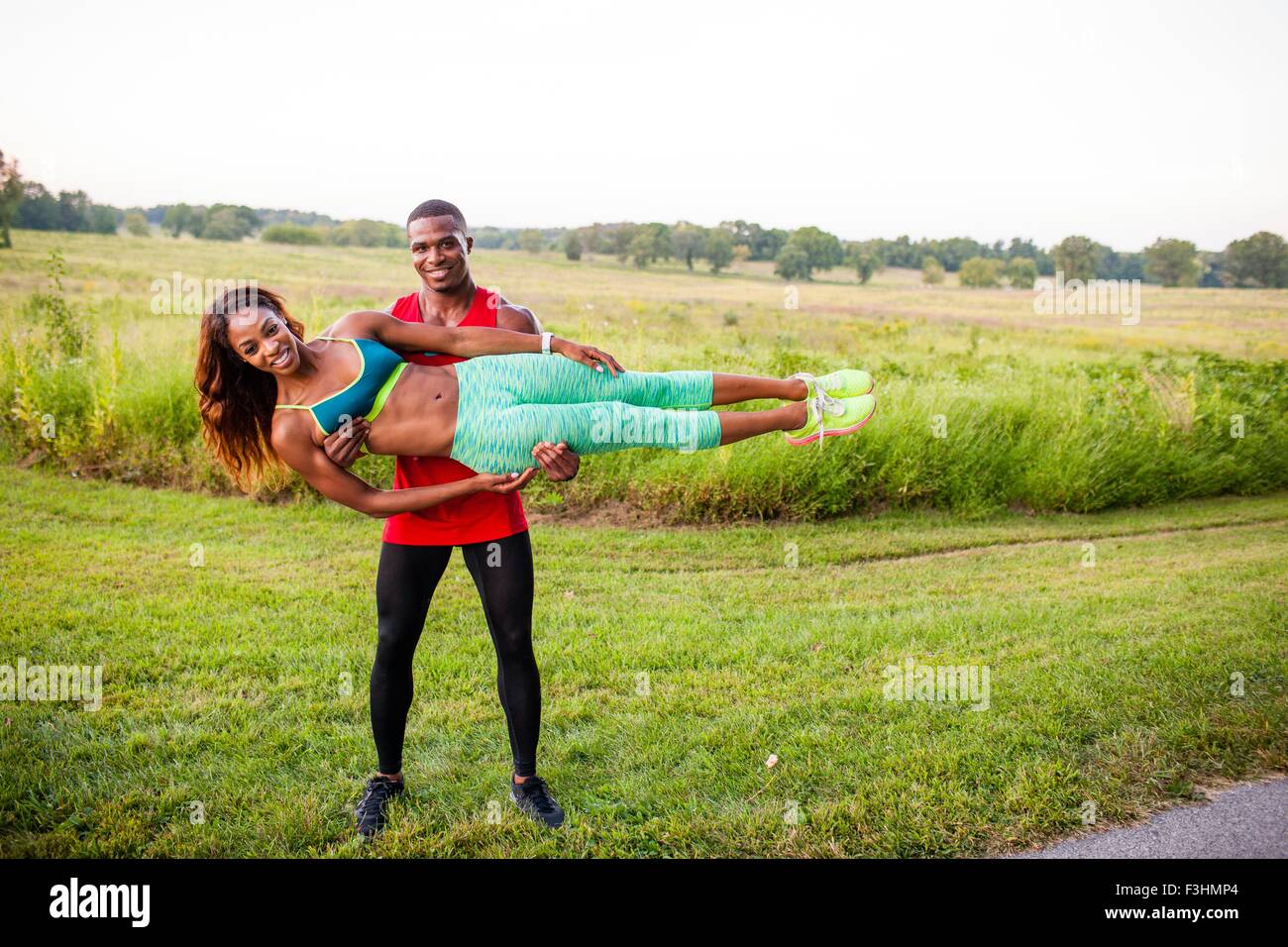 Young man training holding up girlfriend horizontally Stock Photo - Alamy