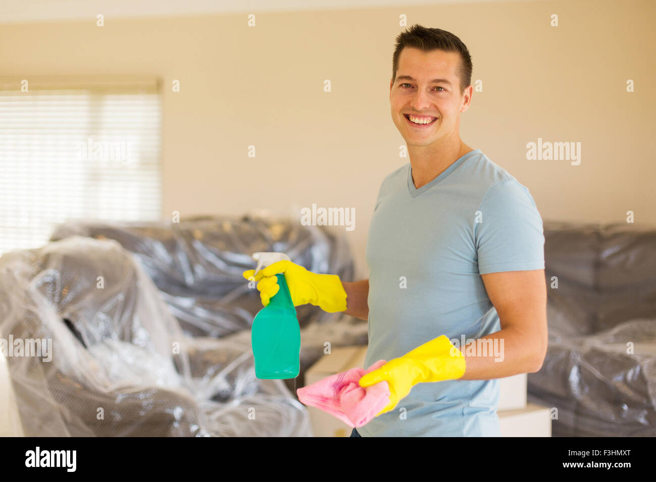 happy young man doing housework at new home Stock Photo - Alamy