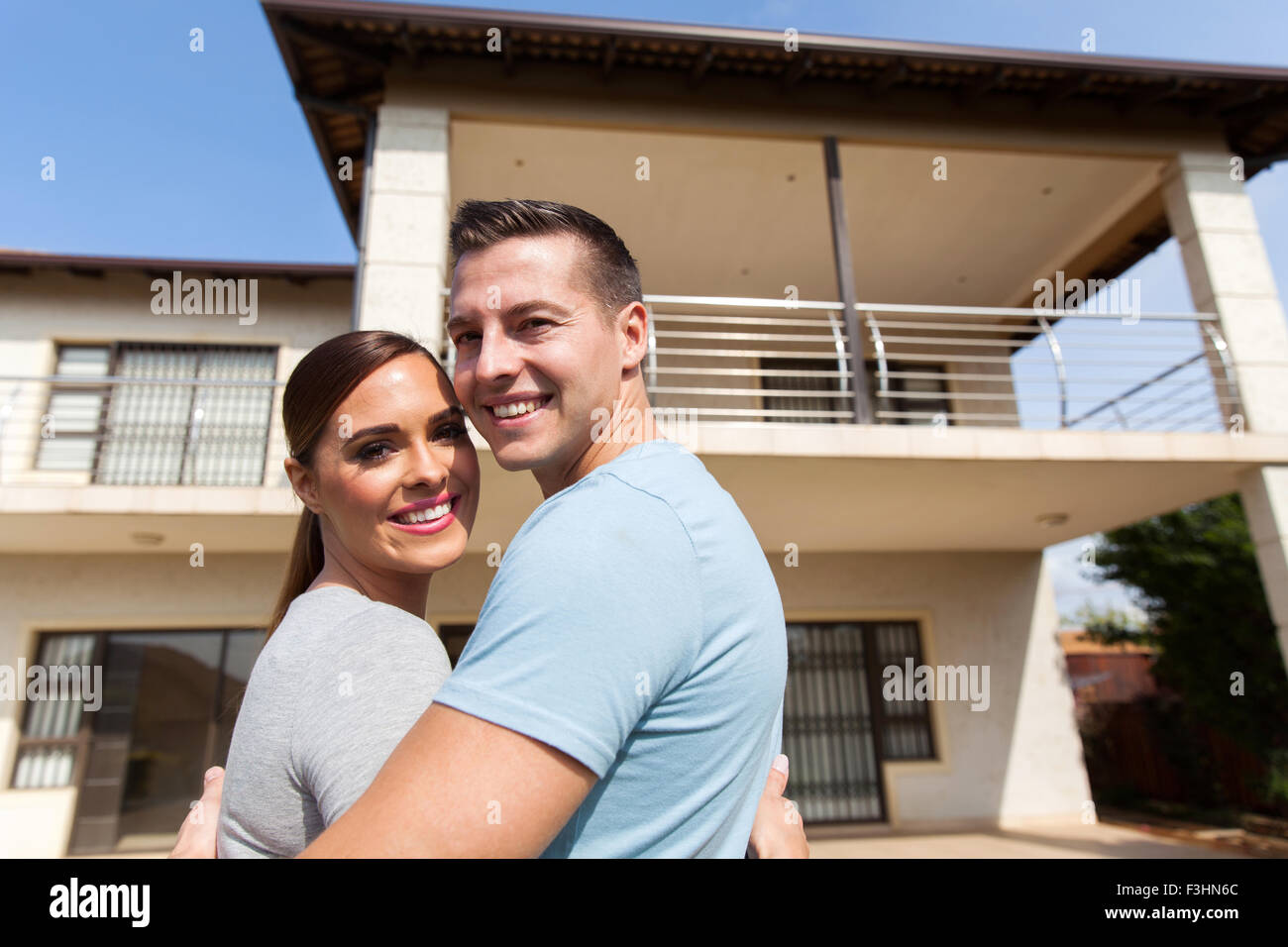 smiling couple looking back in front of their house Stock Photo - Alamy