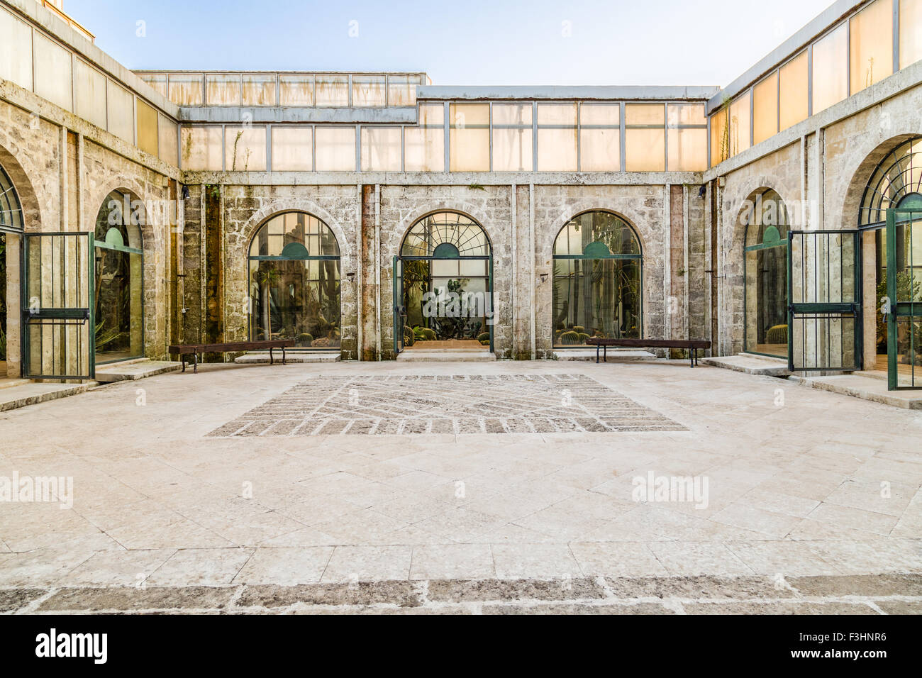paved courtyard of ancient greenhouse of succulents and cactus with ...