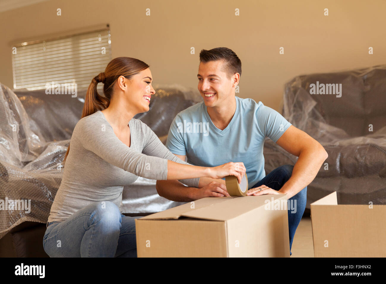 cheerful couple packing for new house Stock Photo - Alamy