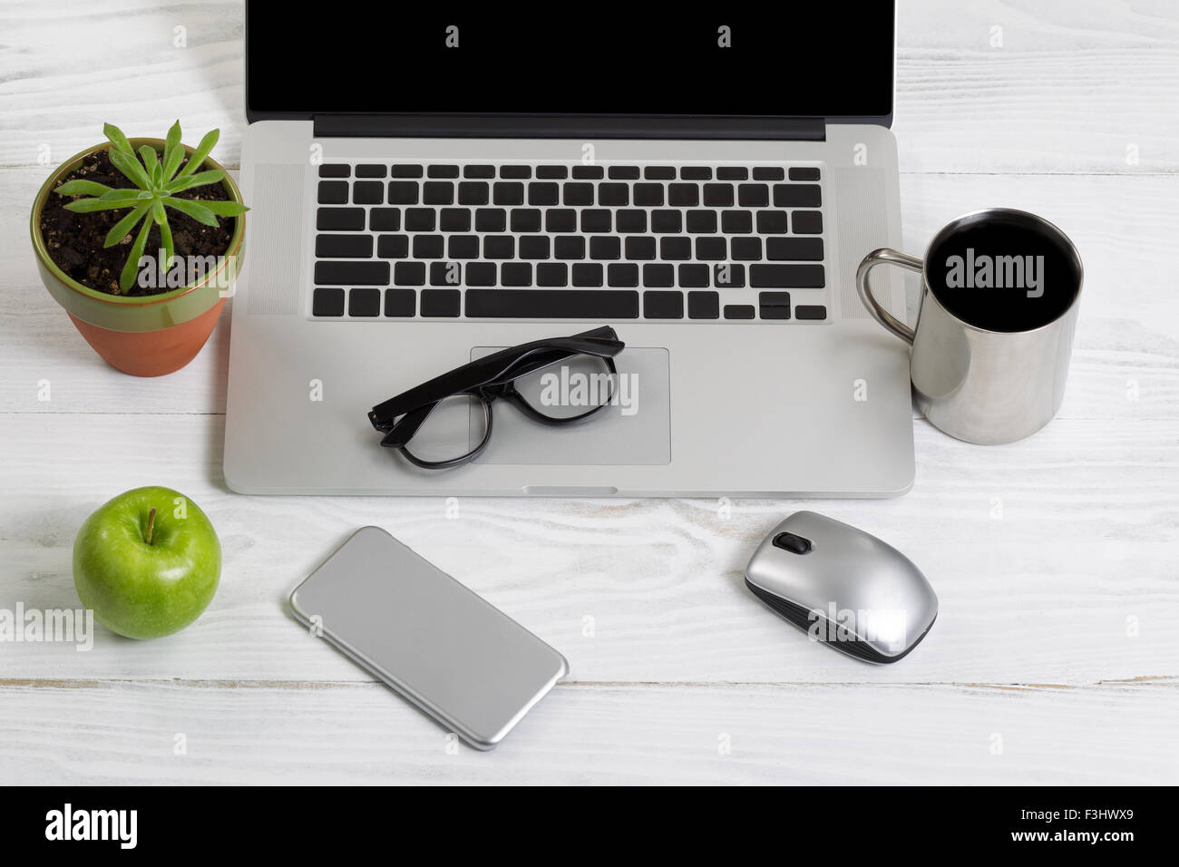 Clean and organized white desktop with office work objects and snacks ...