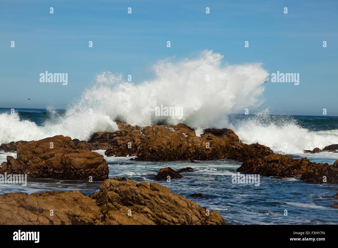 Powerful wave hitting rocks on a beach Stock Photo - Alamy