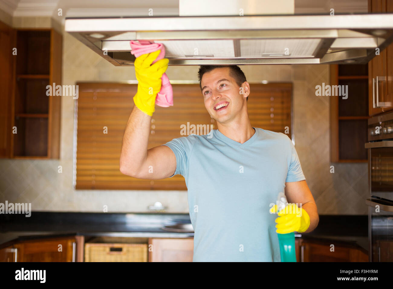 happy young man cleaning kitchen Stock Photo - Alamy
