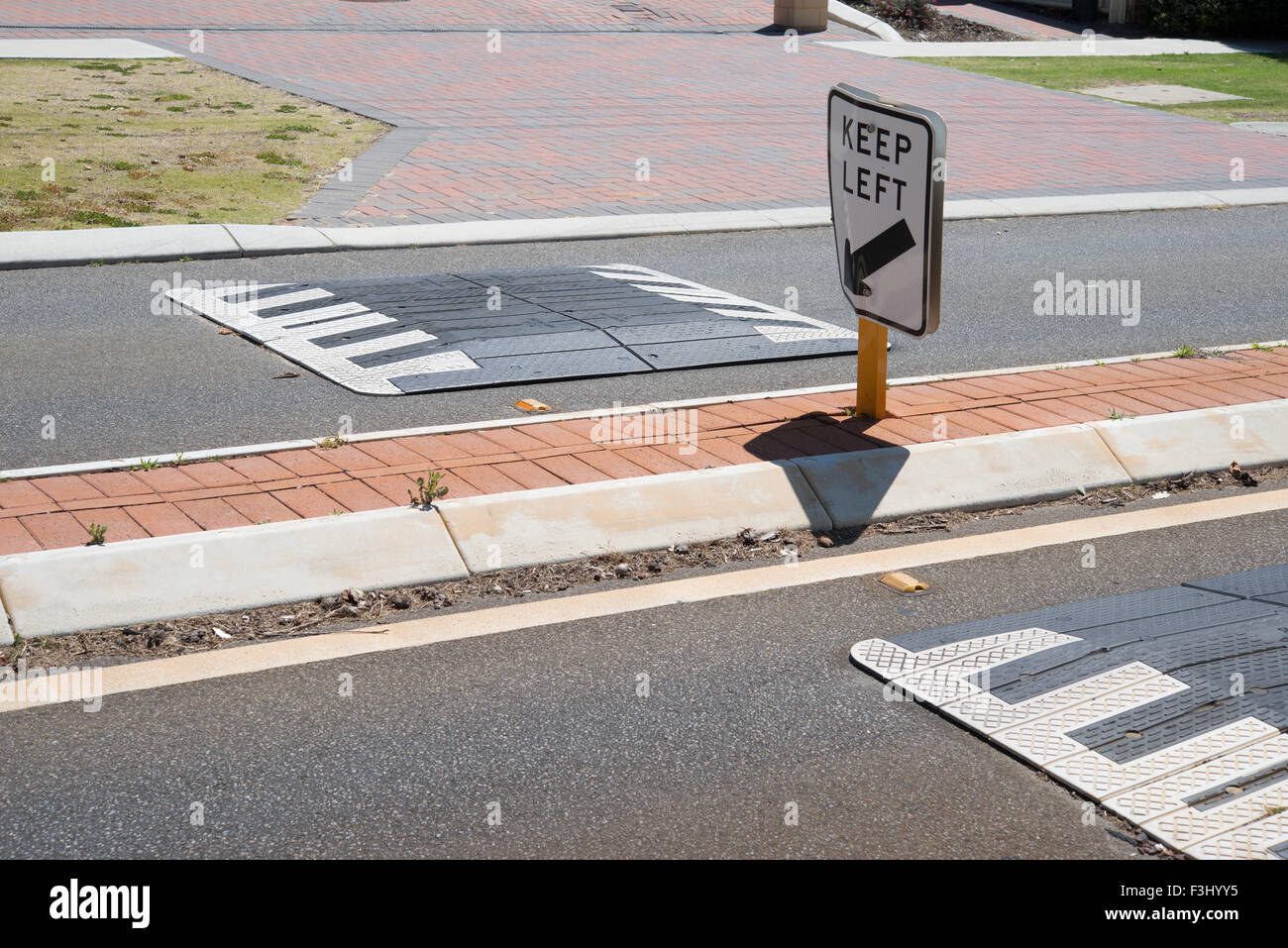 Keep Left and speed hump Stock Photo - Alamy