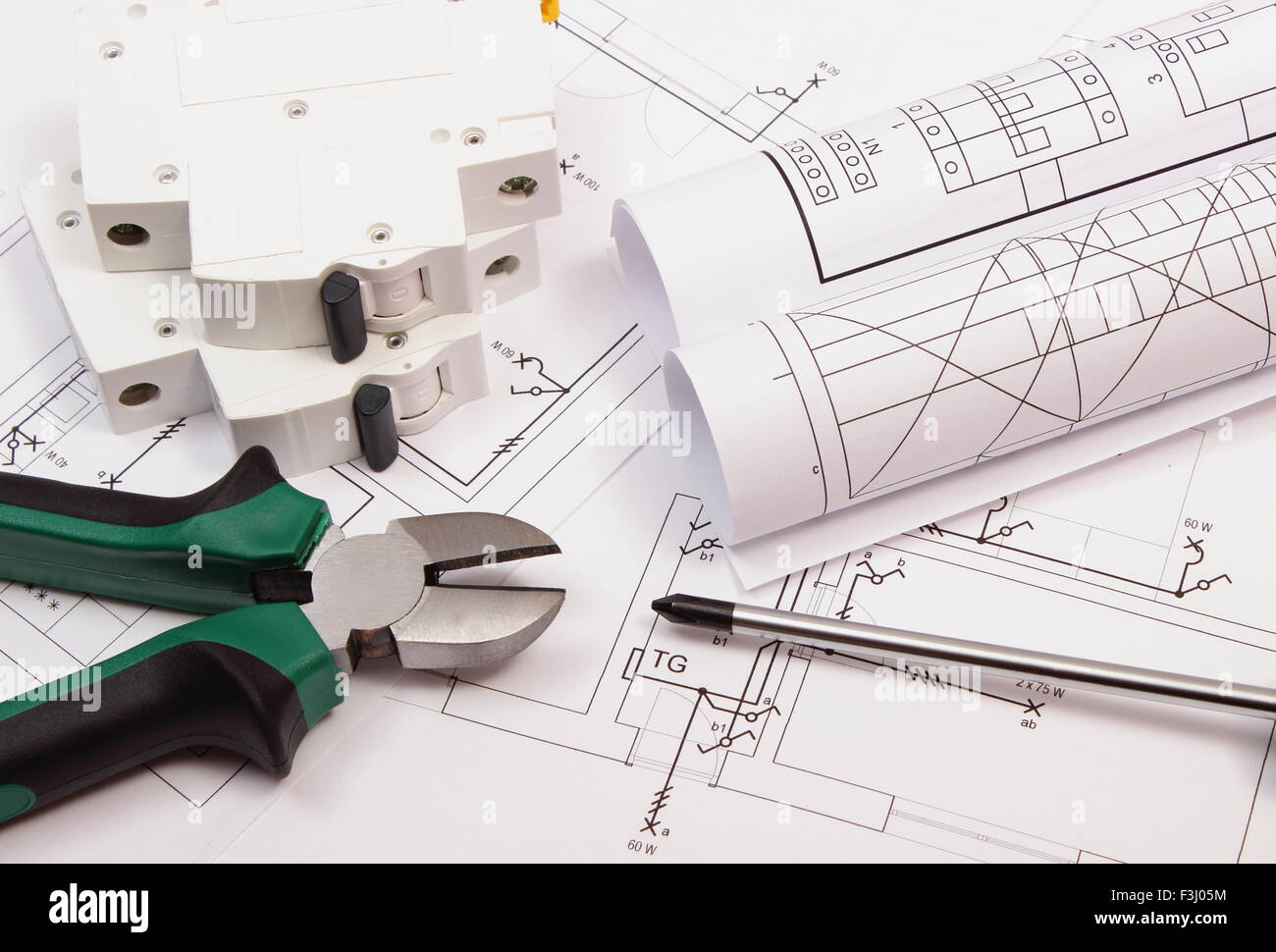 Metal pliers, screwdriver, electric fuse and rolls of diagrams on ...