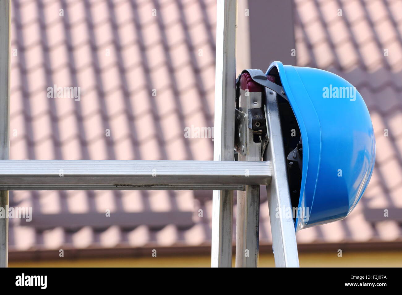 Protective blue helmet on aluminum ladder, concept of security and ...