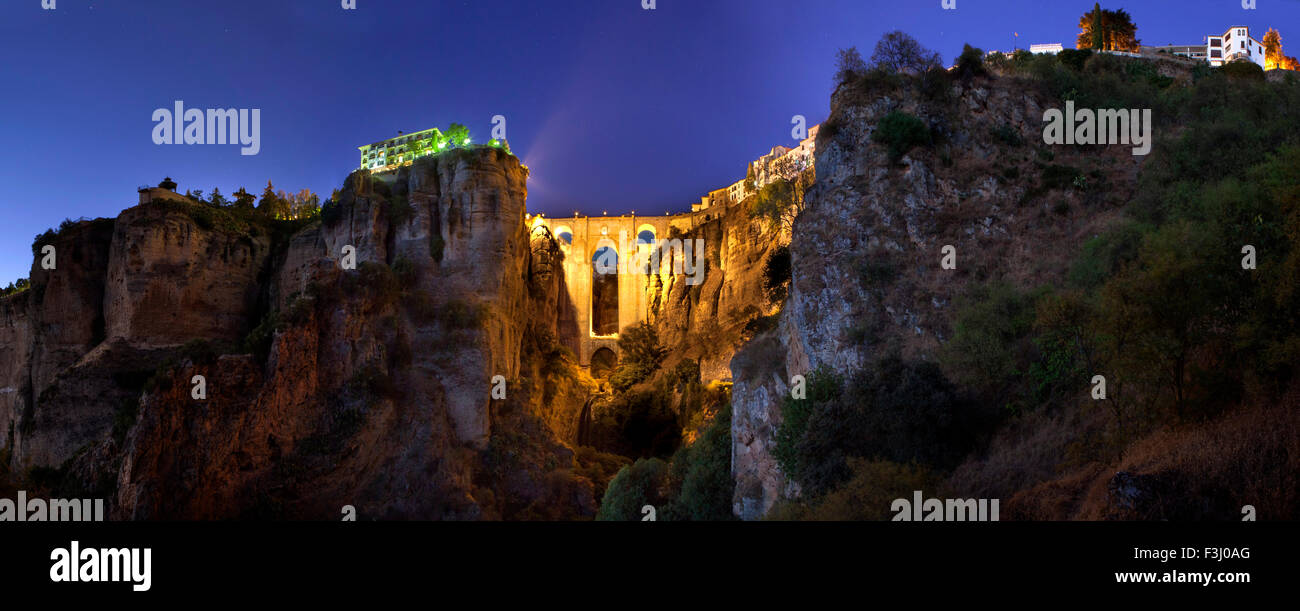 illuminated Puente Nuevo Bridge from outskirts of Ronda at sunset ...