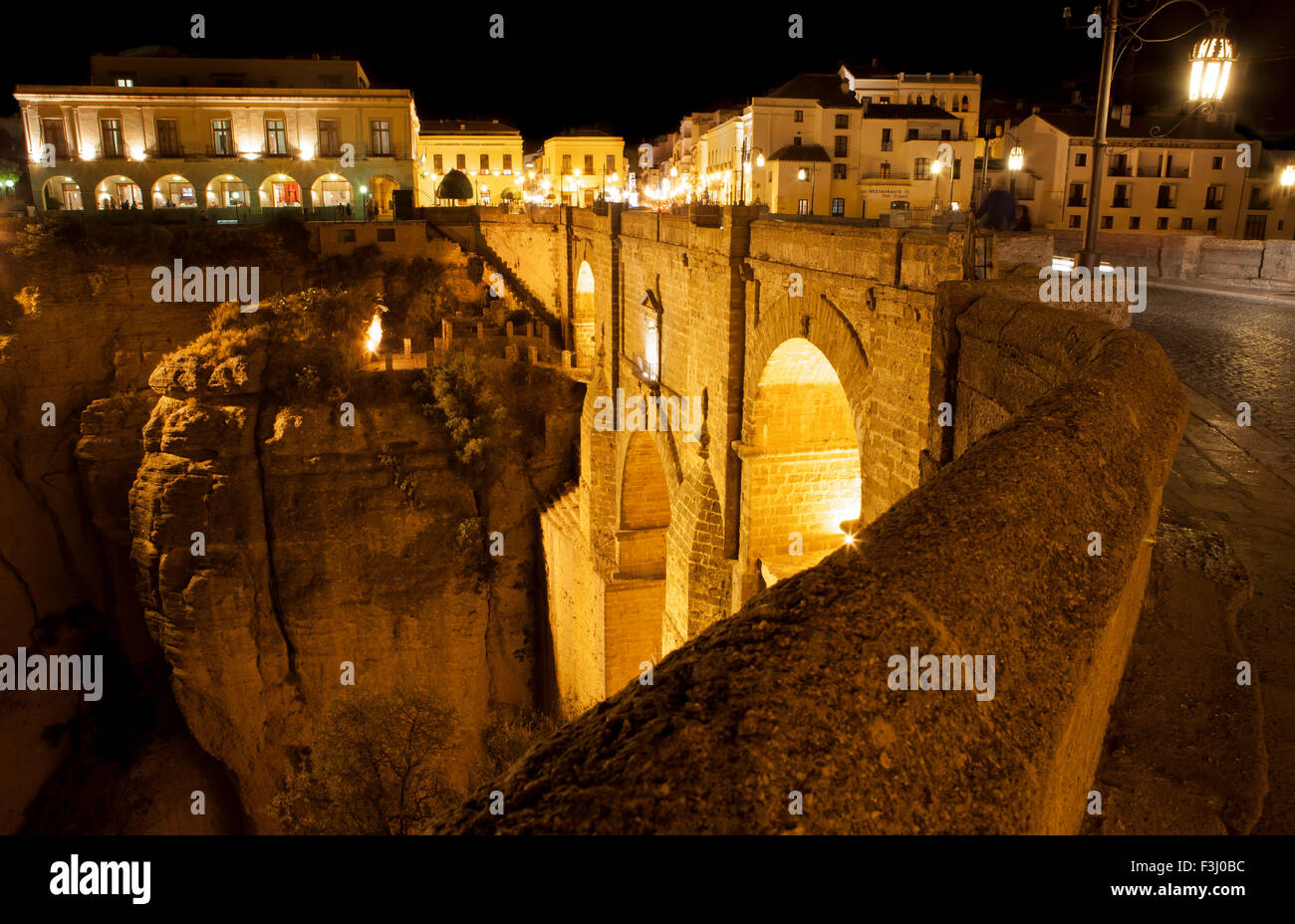 Illuminated puente nuevo bridge from outskirts of ronda at sunset hi ...