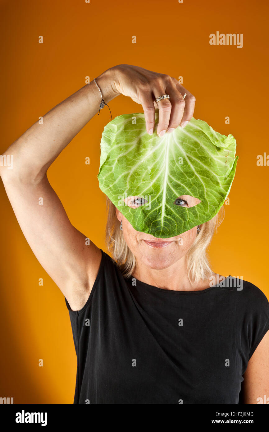 Cute woman holding a cabbage as a mask. Can be used for healthy food ...