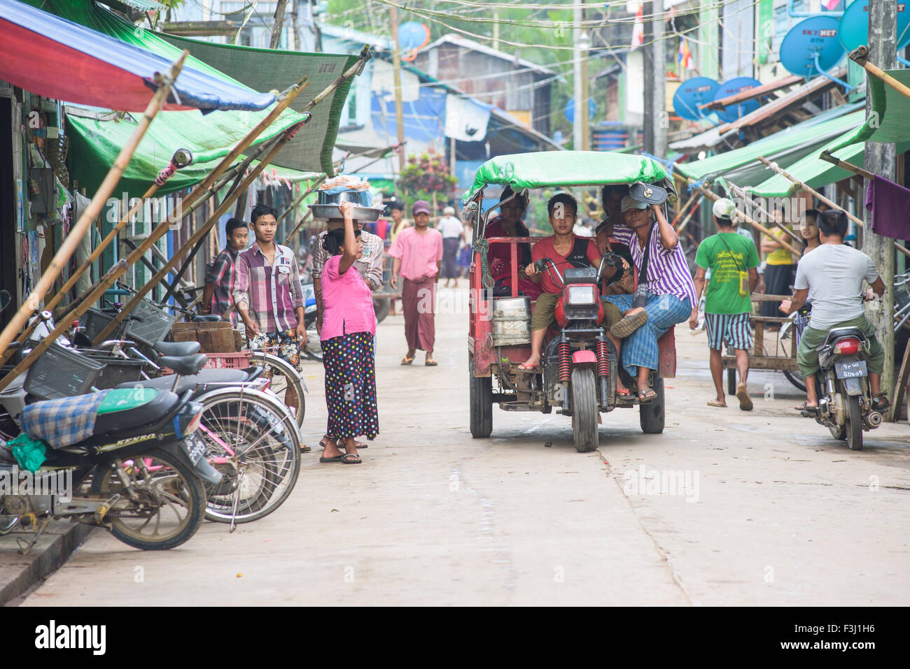 Three wheel bus with passengers on its way through the central market ...