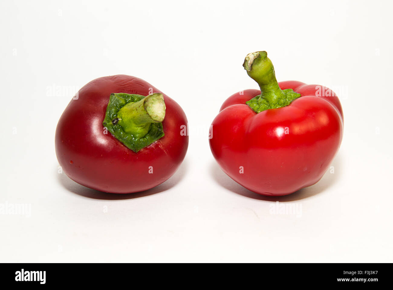 Two red peppers on a white background Stock Photo - Alamy